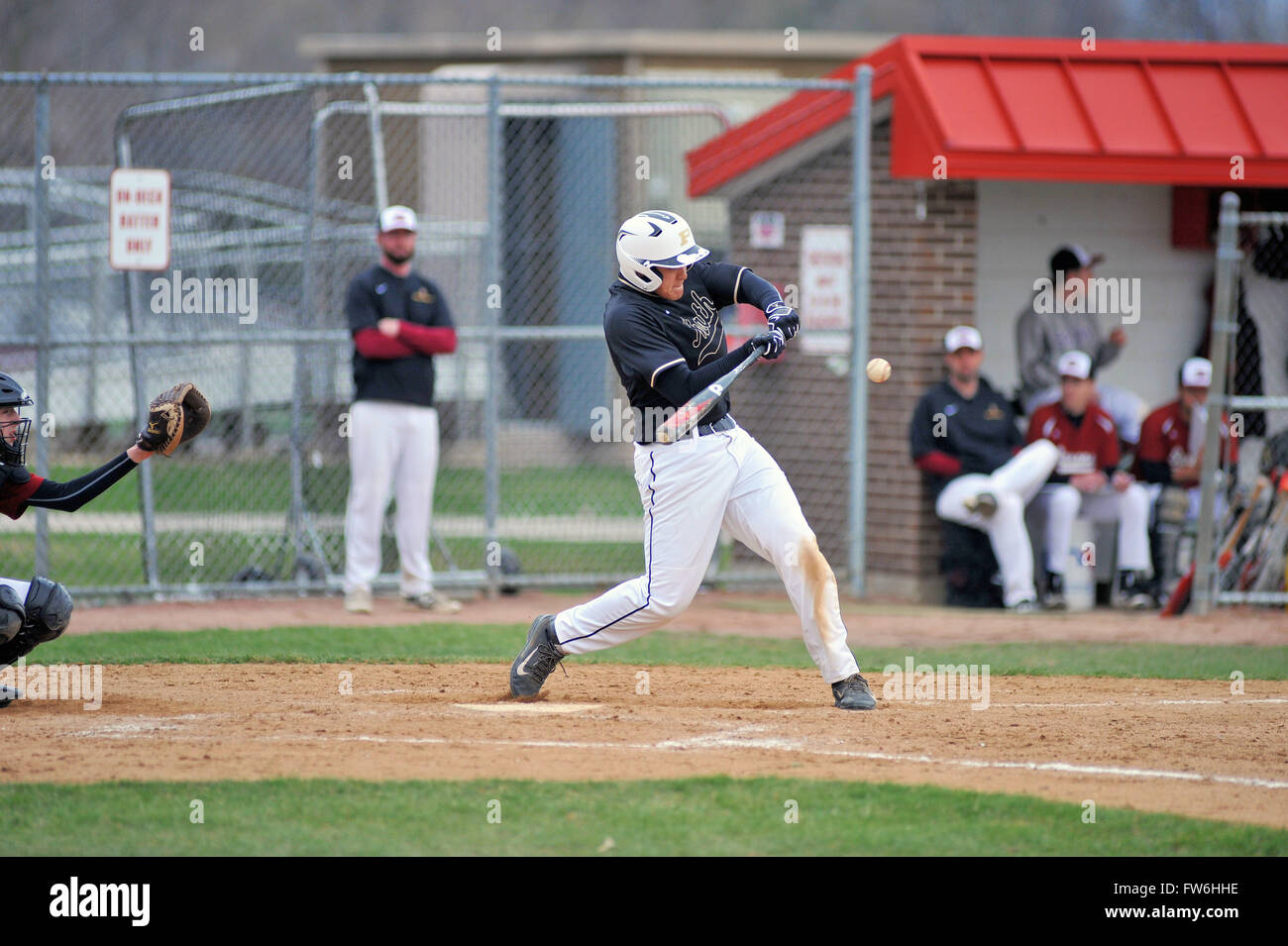 Batter making contact during an early season varsity high school ...