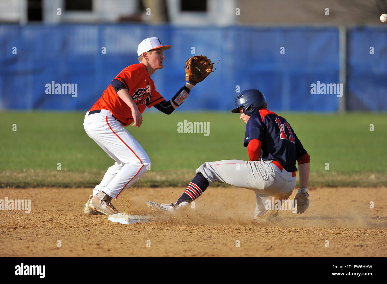 A runner sliding into second well ahead of the throw as the opposing ...