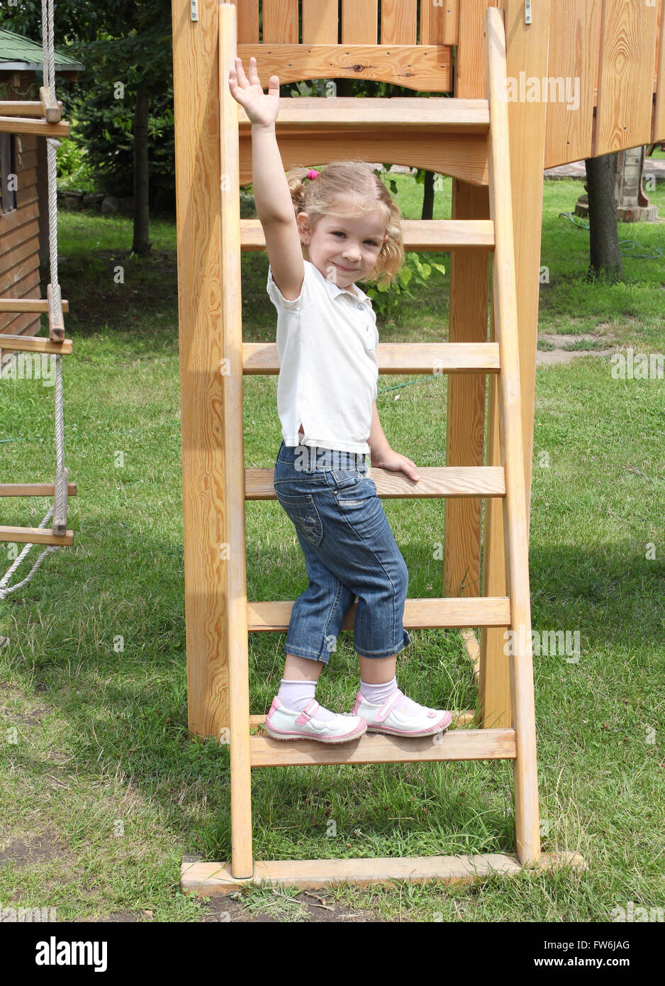 happy little girl standing on ladder Stock Photo - Alamy