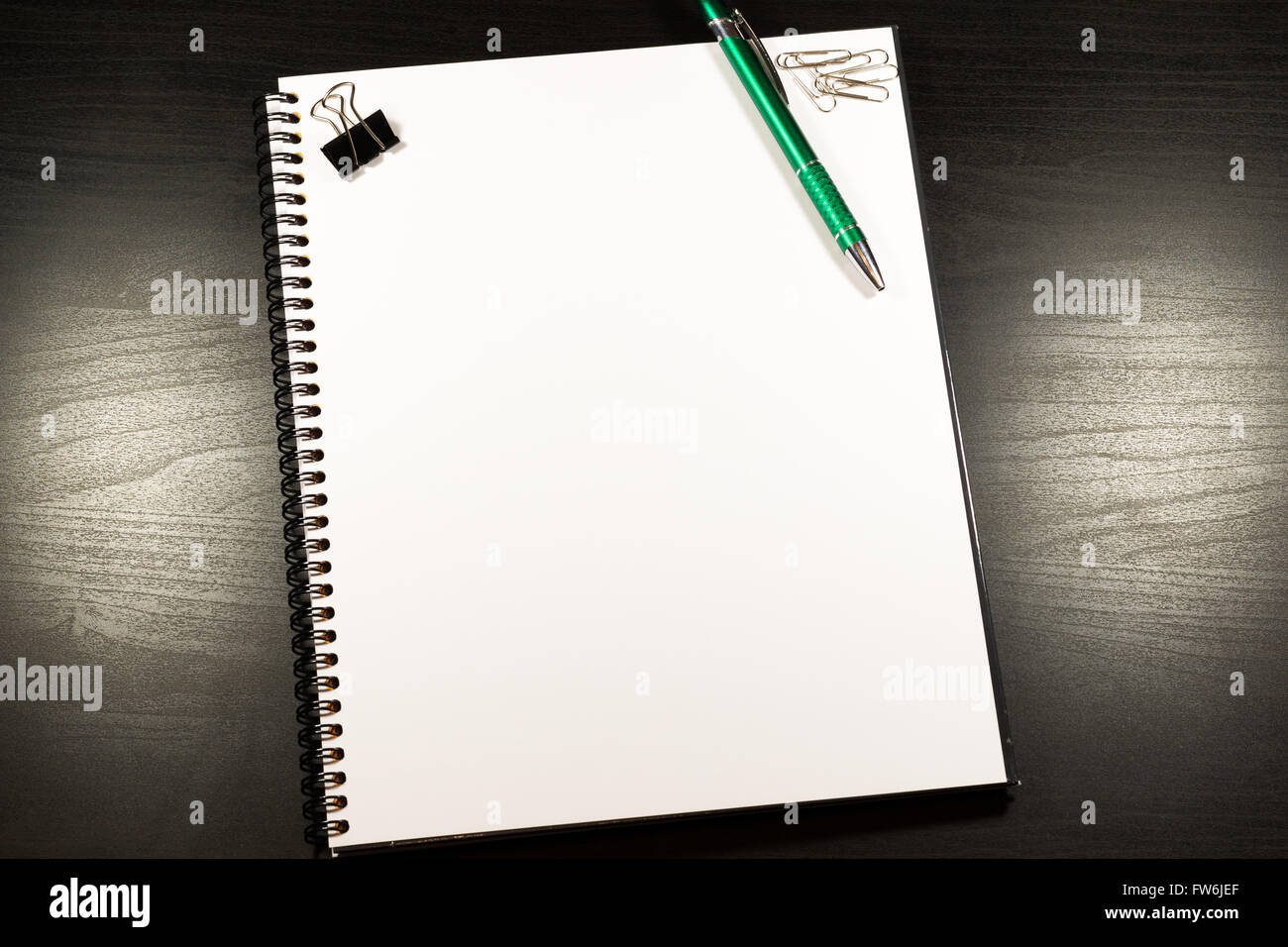 Notebook with blank paper, color sticky notes, pen and clips on a ...