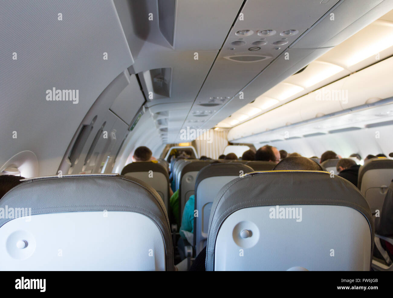 Interior of airplane with passengers on seats Stock Photo - Alamy