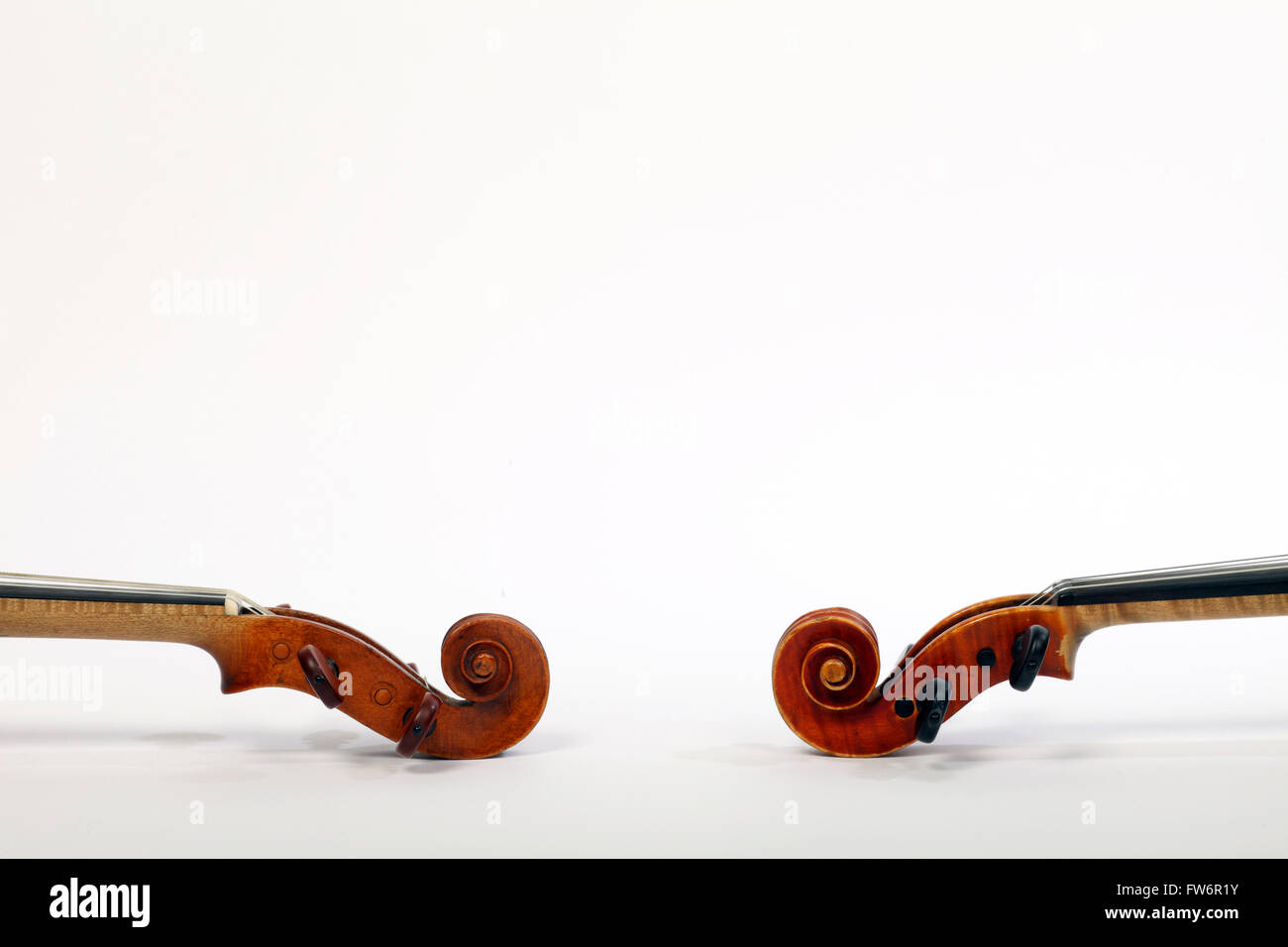 Two violin scrolls, one baroque, one classical violin Stock Photo - Alamy