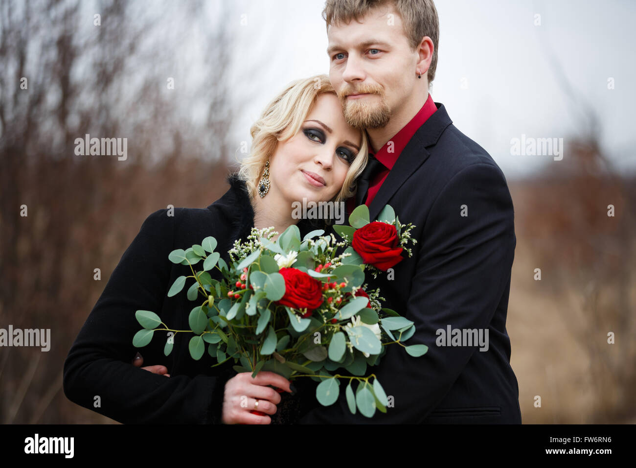 Happy hugging wedding couple with bouquet in the wood Stock Photo - Alamy