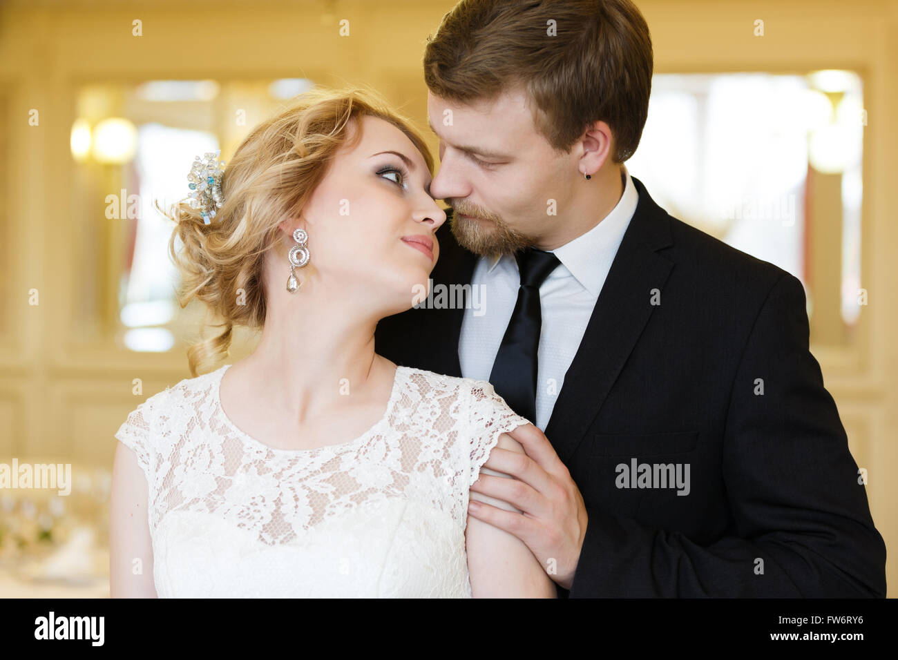 Hugging wedding couple in a bright room Stock Photo - Alamy