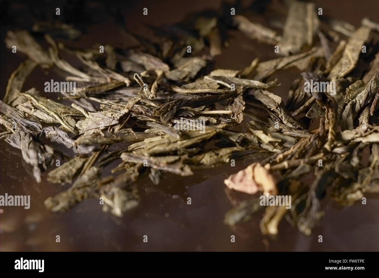 Dried tea leaves on a dark reflective surface Stock Photo - Alamy