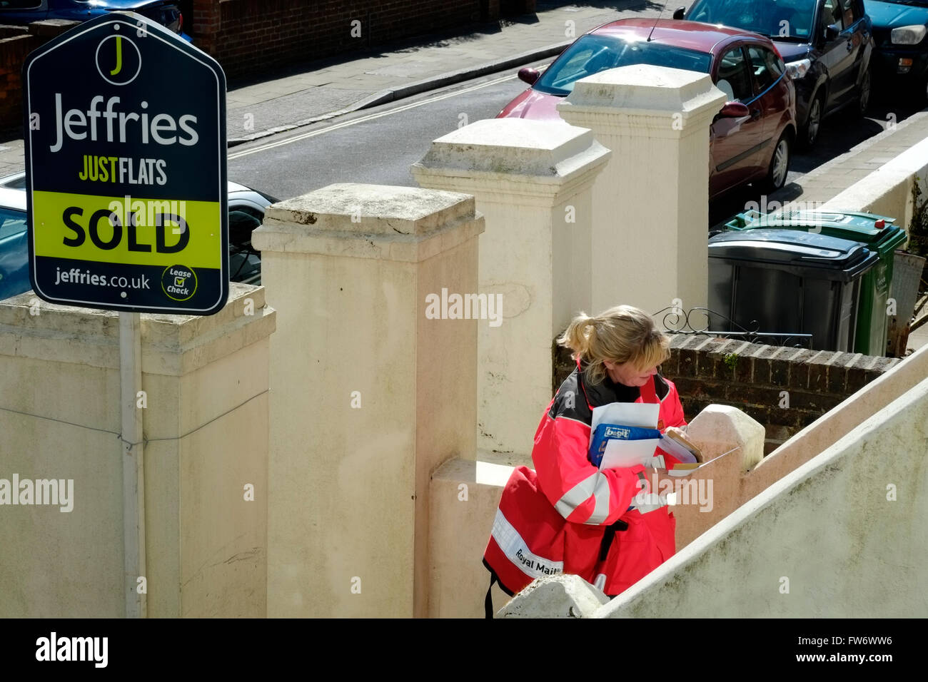 female postal worker delivering letters to a house in england uk Stock ...