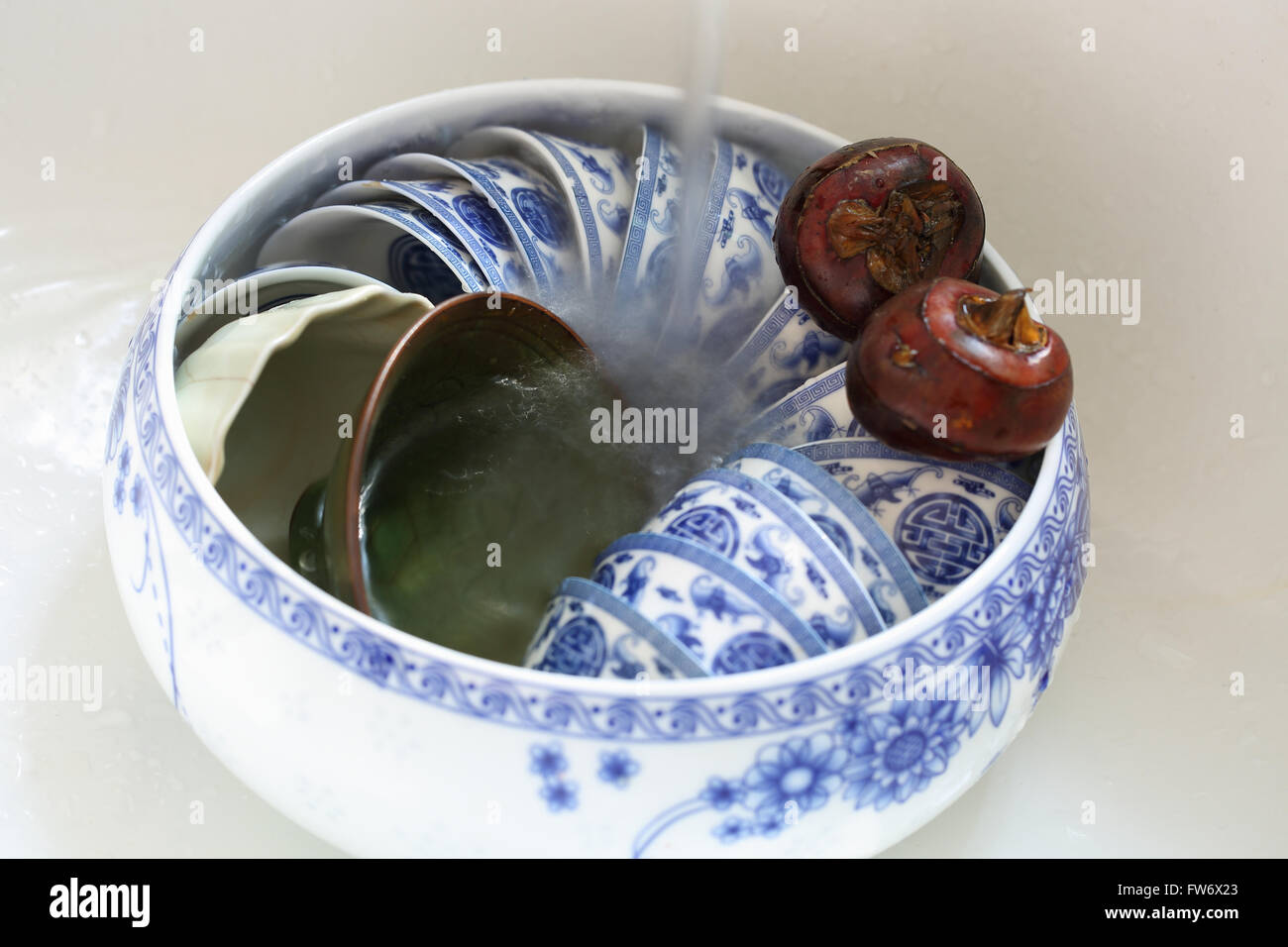A pot of tea cups and two water chestnut Stock Photo - Alamy