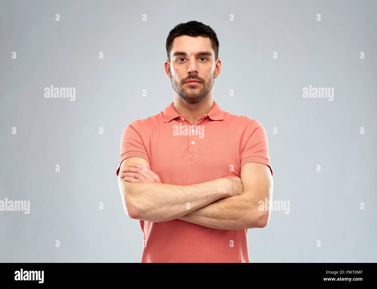 young man with crossed arms over gray background Stock Photo - Alamy