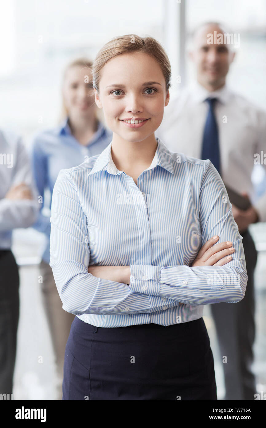 smiling businesswoman with colleagues in office Stock Photo - Alamy