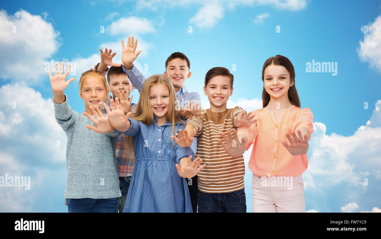 happy children waving hands over blue sky Stock Photo - Alamy