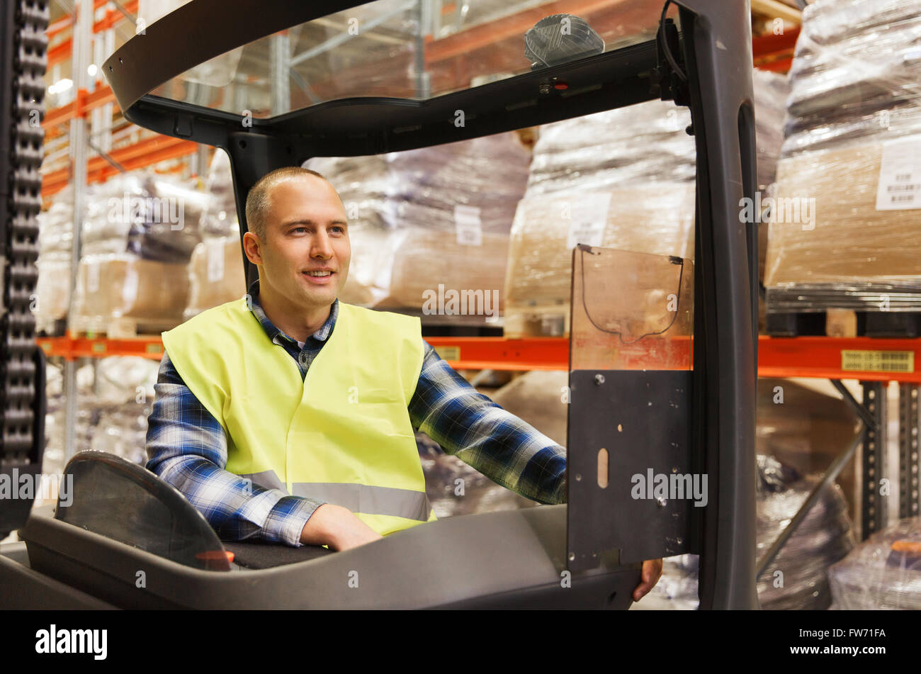 smiling man operating forklift loader at warehouse Stock Photo - Alamy