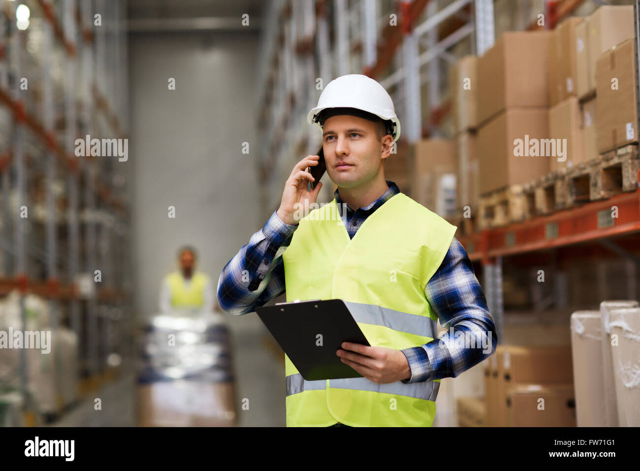 man with clipboard and smartphone at warehouse Stock Photo - Alamy