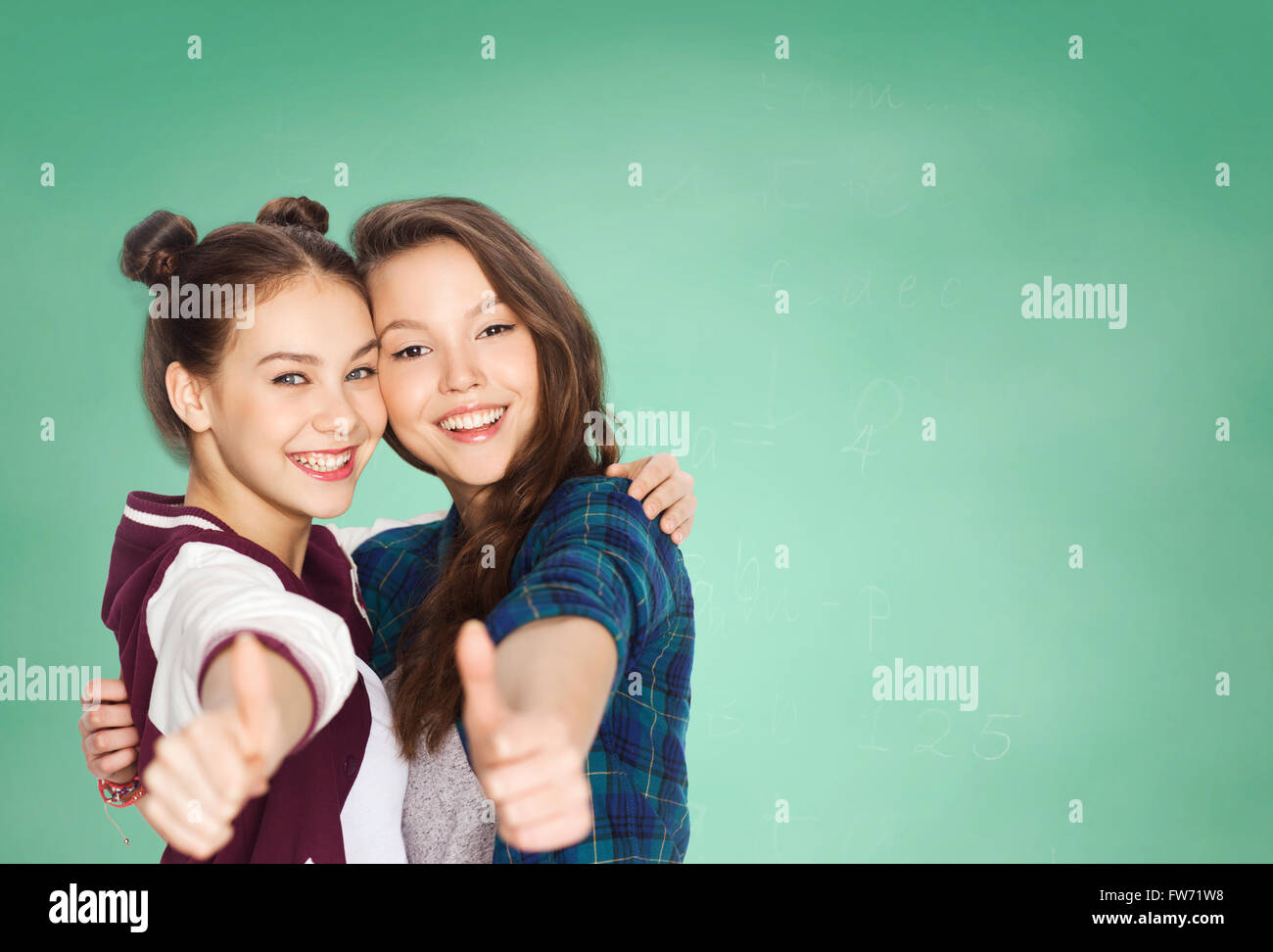 happy teenage student girls showing thumbs up Stock Photo - Alamy