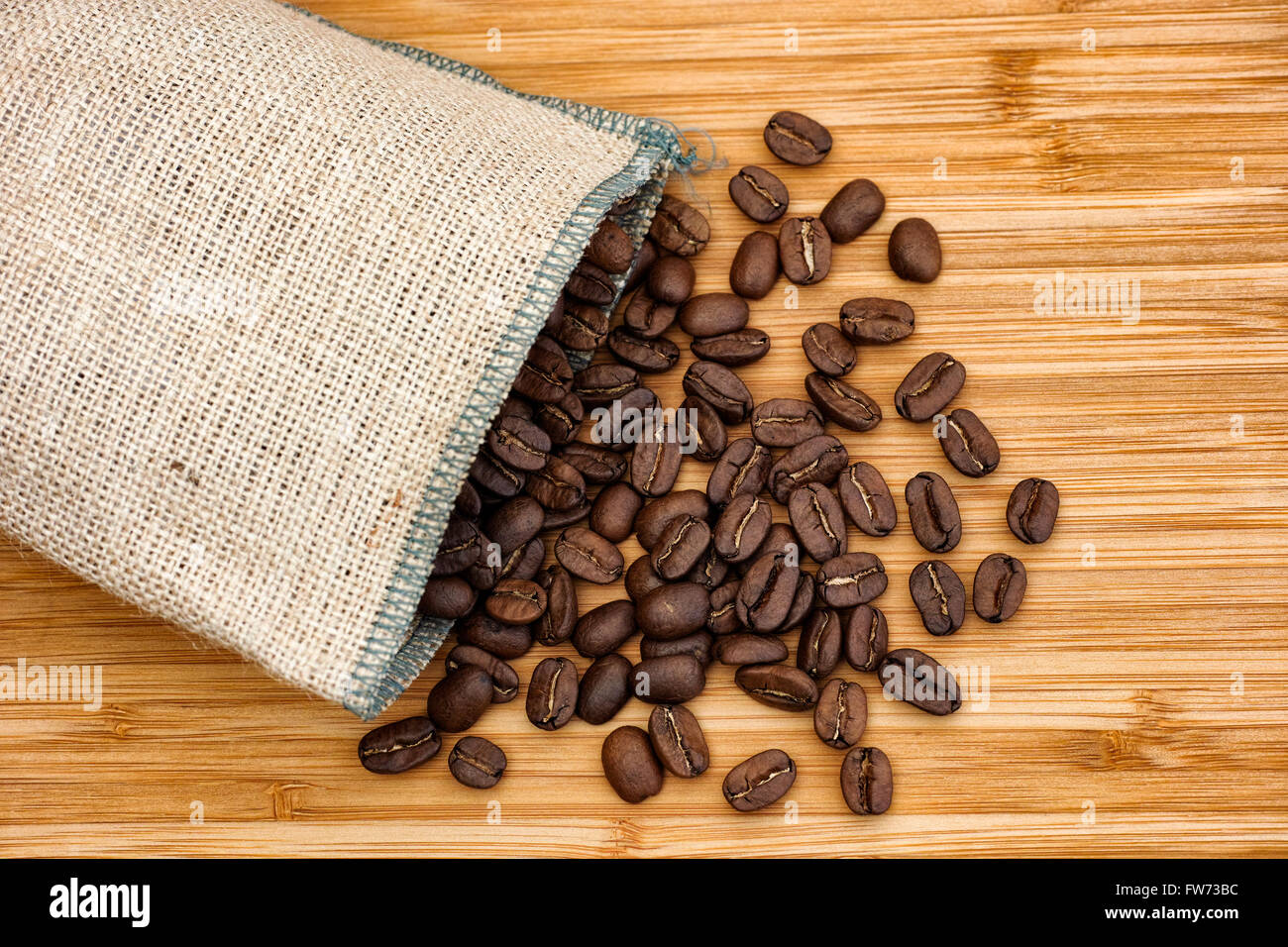 Coffee beans spilling out of burlap bag. Close up Stock Photo - Alamy