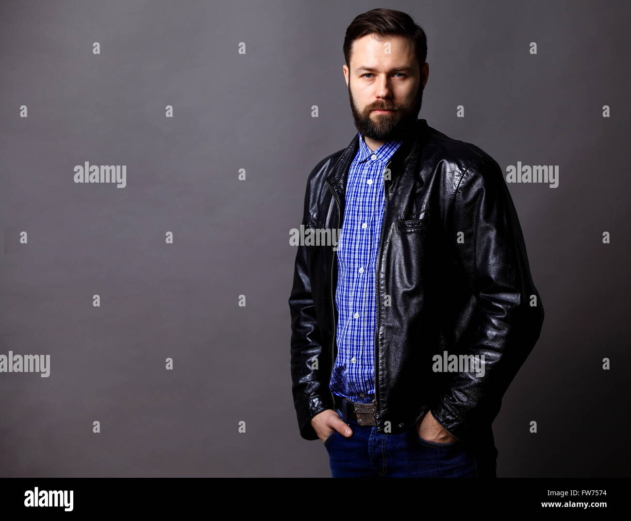 Attractive Young Man Wearing Leather Jacket on gray Stock Photo - Alamy