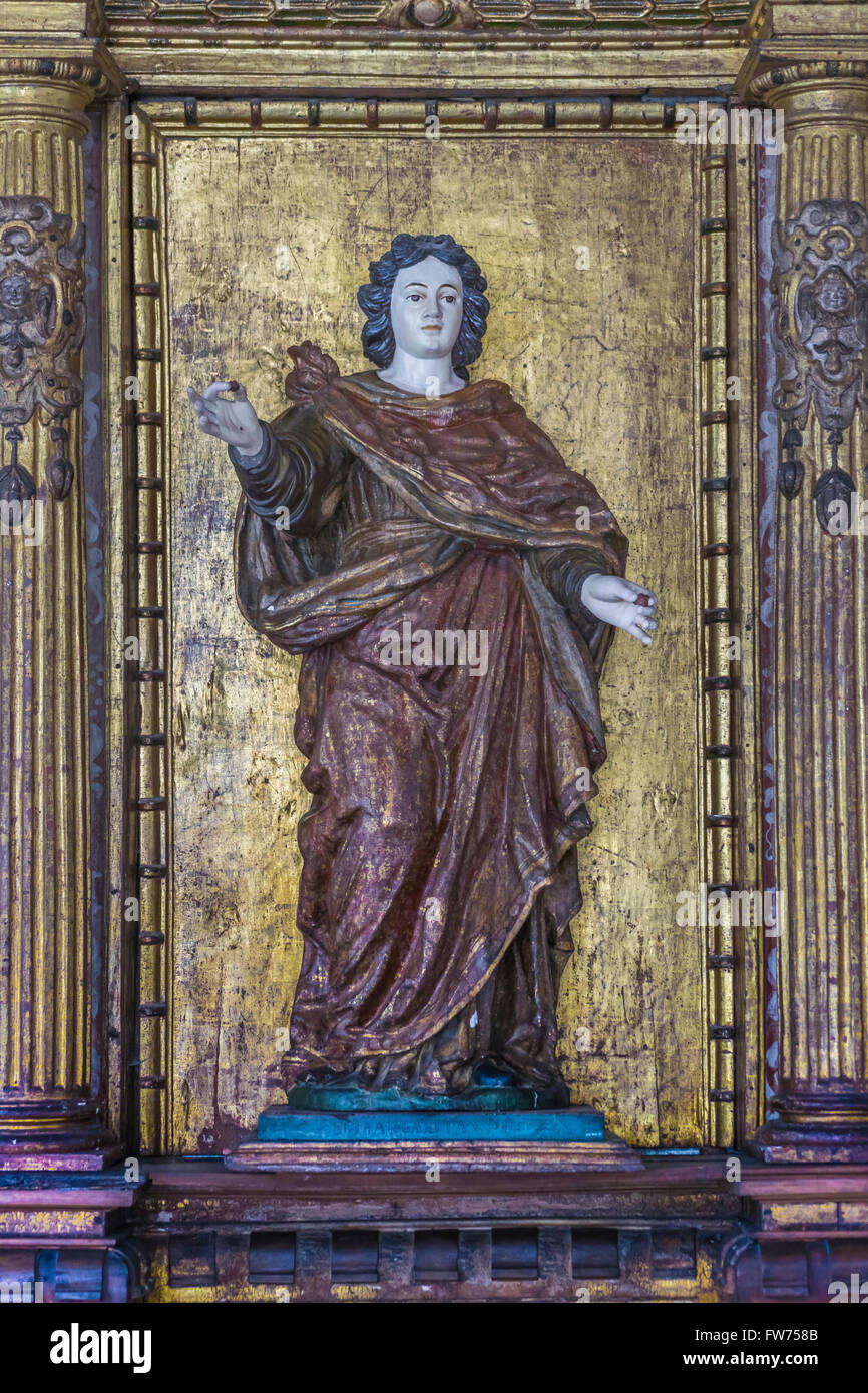 Front view photo of catholic man saint wooden sculpture surrounded by ...