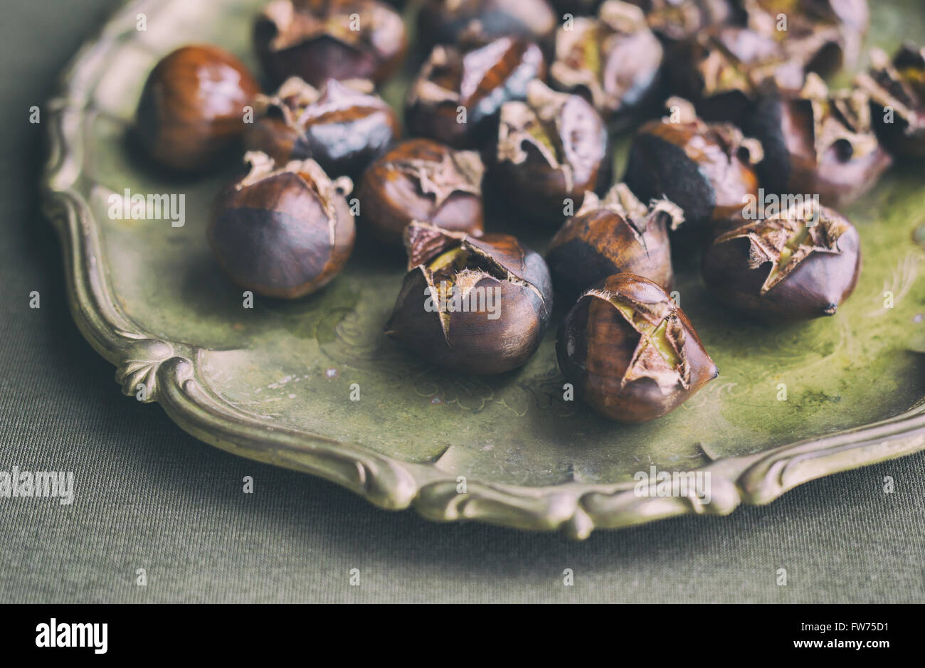 Roasted chestnuts on an old gold plate Stock Photo - Alamy