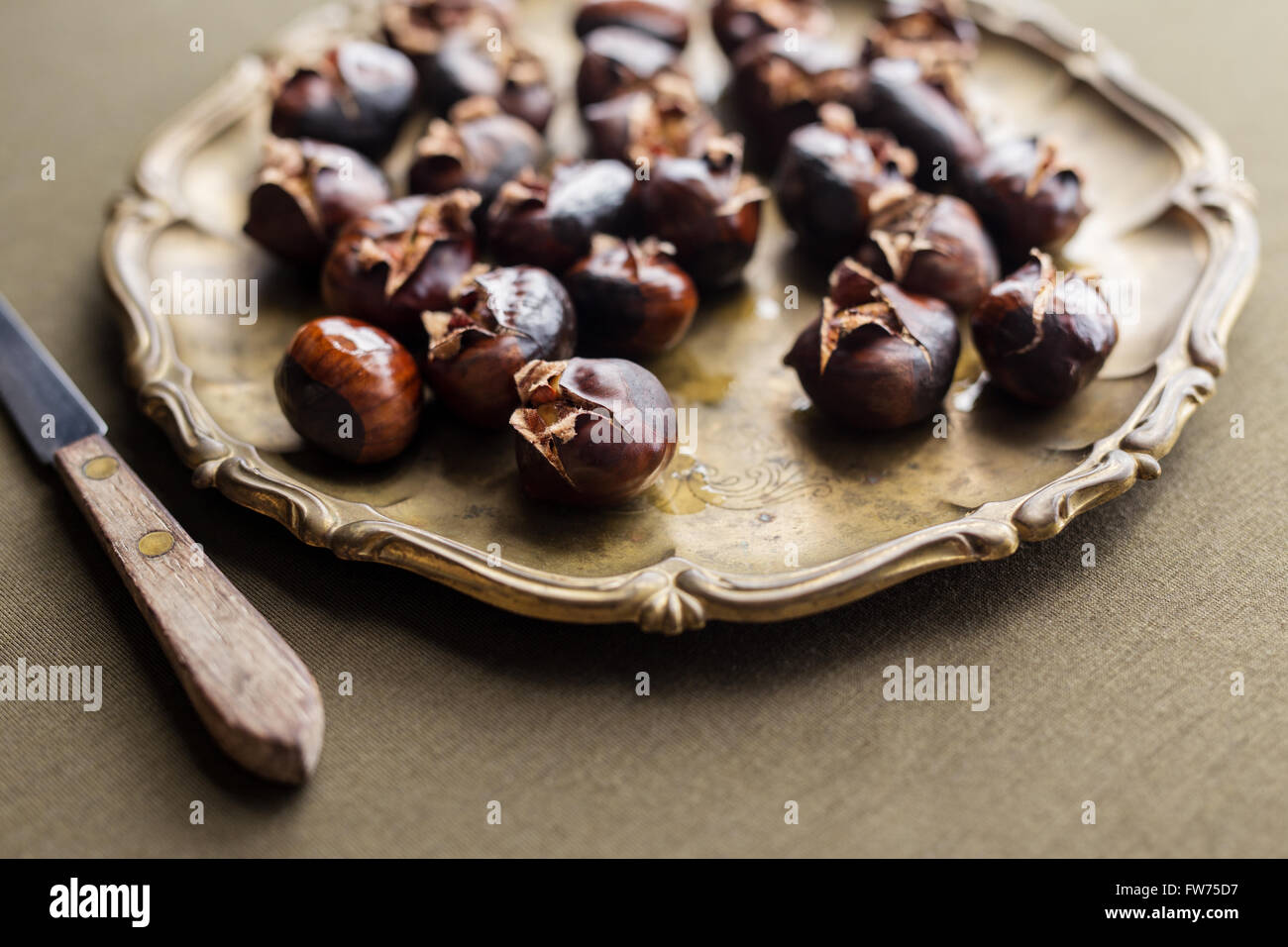 Roasted chestnuts on an old gold plate Stock Photo - Alamy