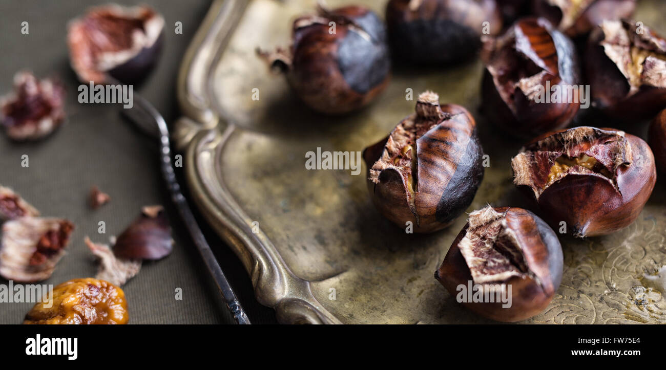 Roasted chestnuts on an old gold plate Stock Photo - Alamy