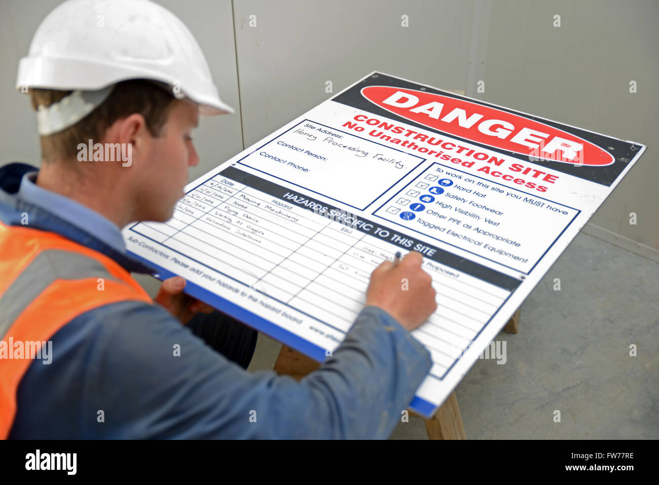 A builder fills out the hazards board to be posted outside the ...