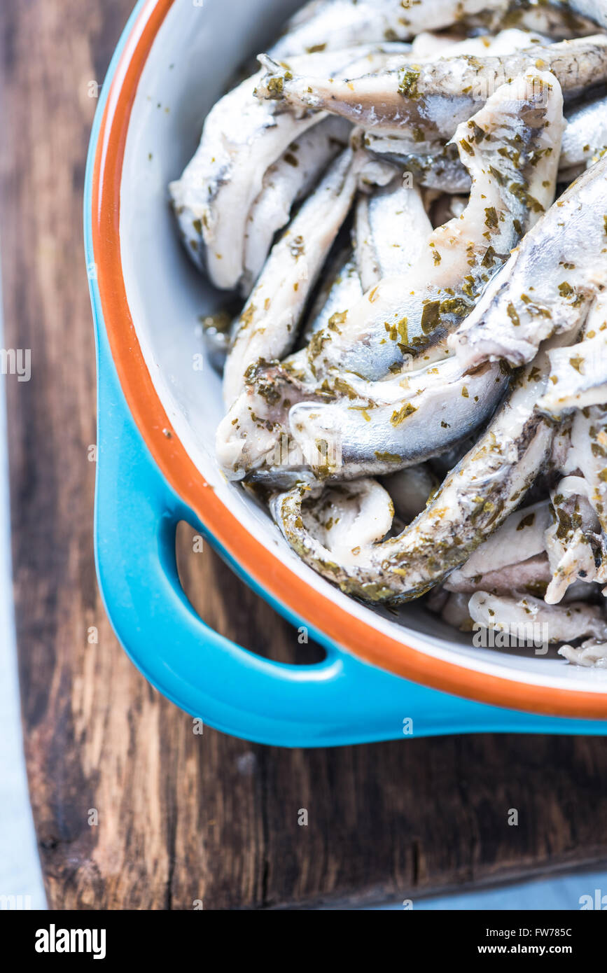 Anchovy with herbs in traditional tapas ceramic bowl, from overhead on ...