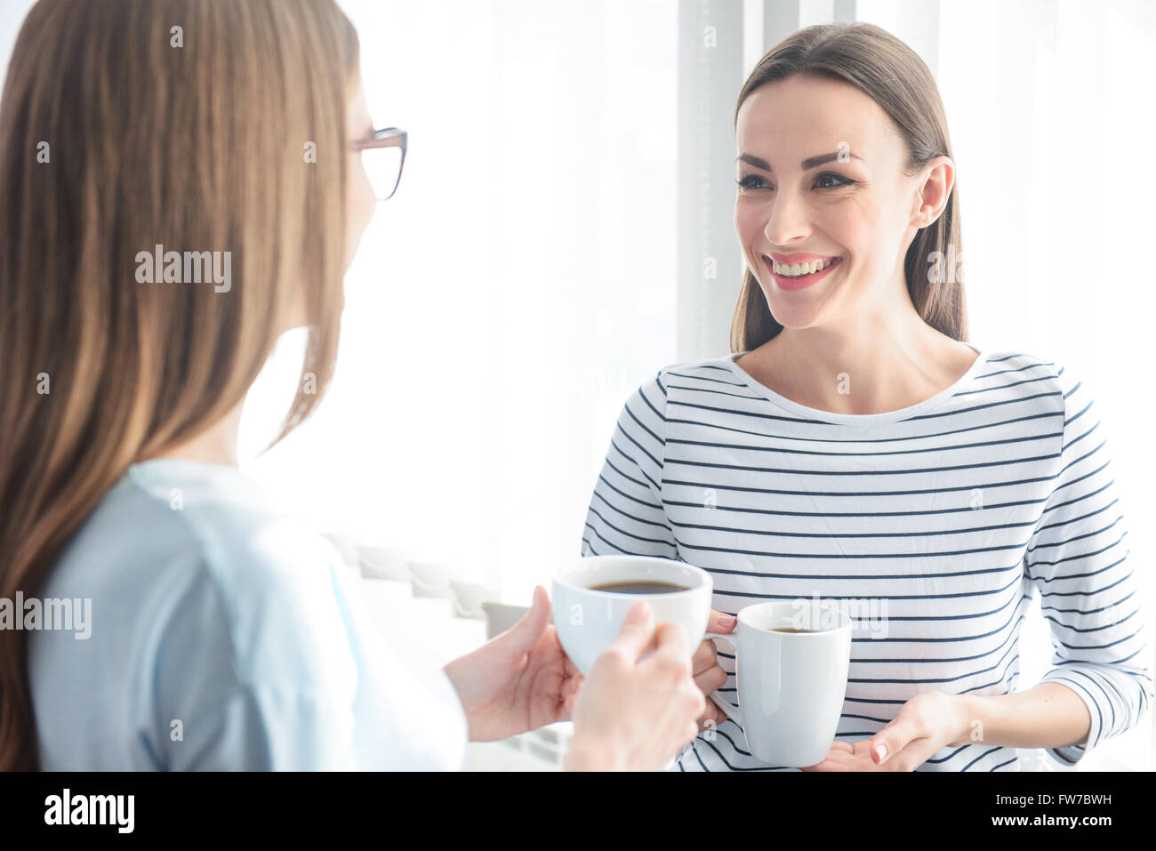 Positive friends having pleasant conversation Stock Photo - Alamy
