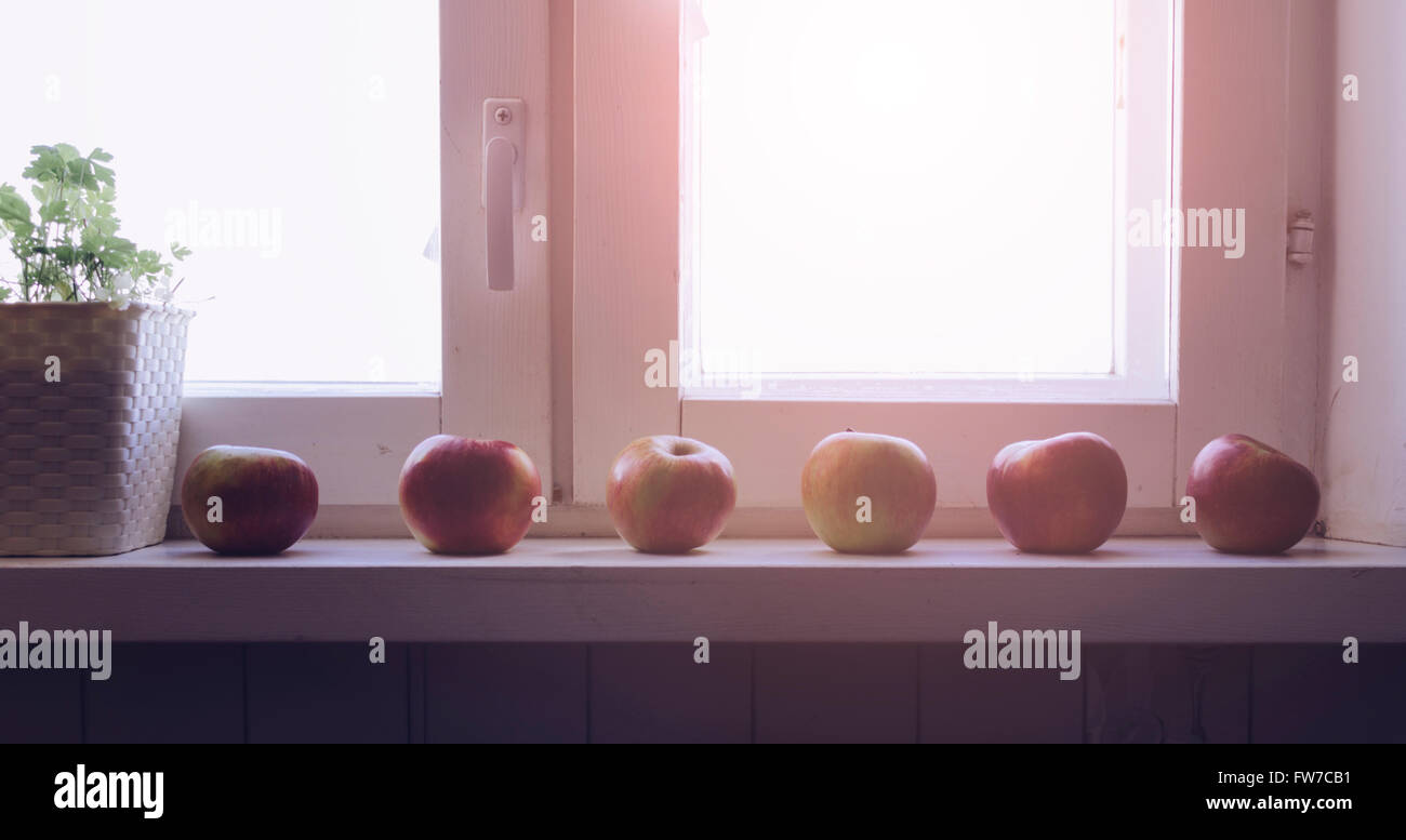 Apples and plant on the home room window in sunset time with soft light ...