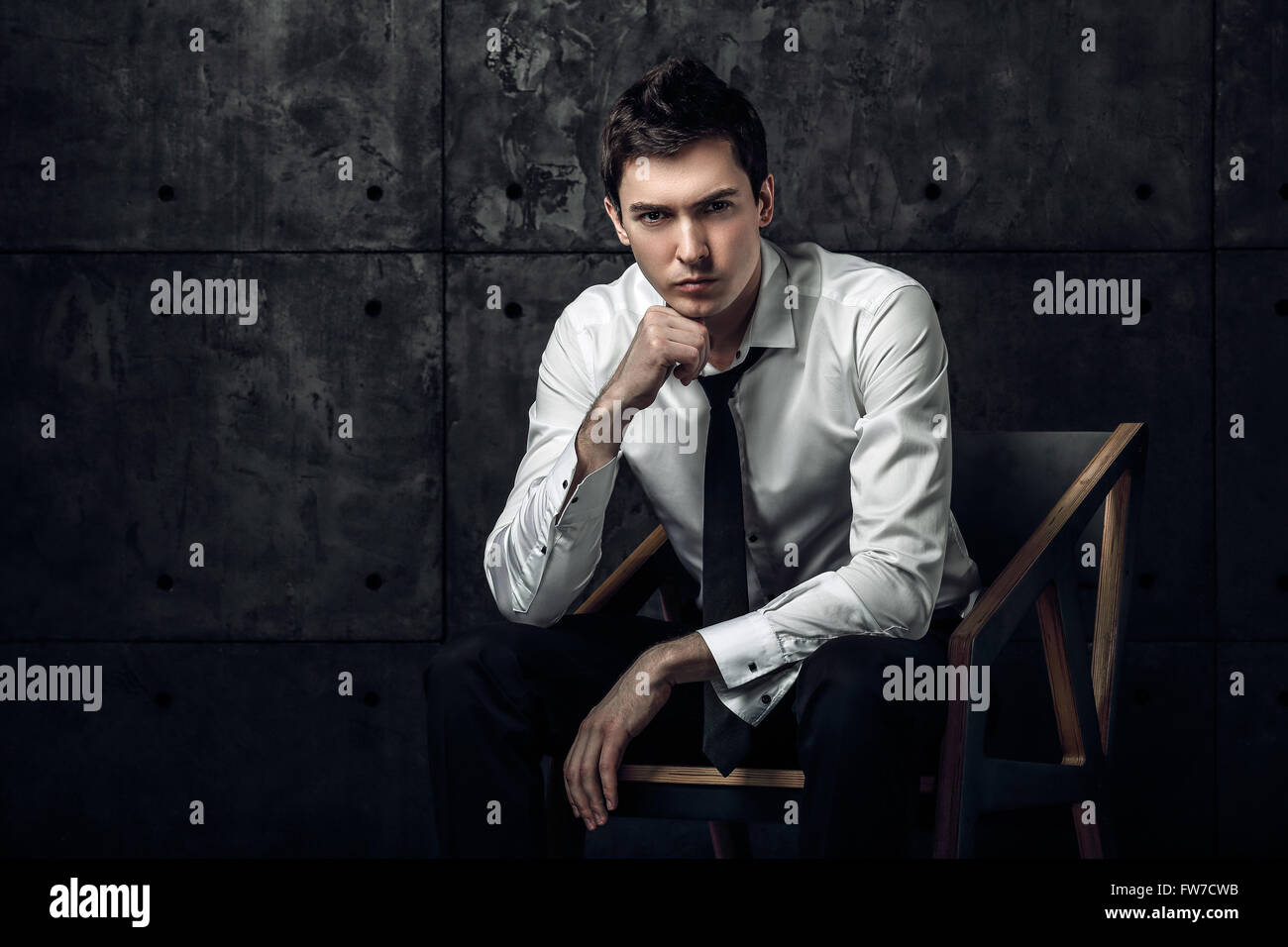 Successful businessman sitting on a chair Stock Photo - Alamy