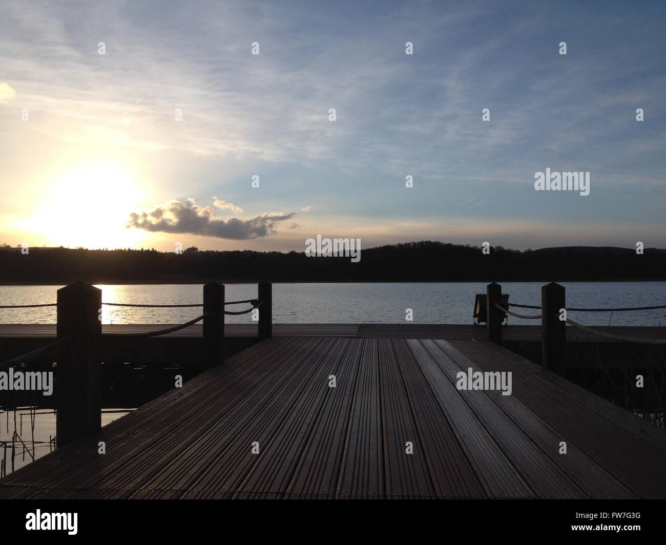 On a waterfront pier watching the sunset Stock Photo - Alamy