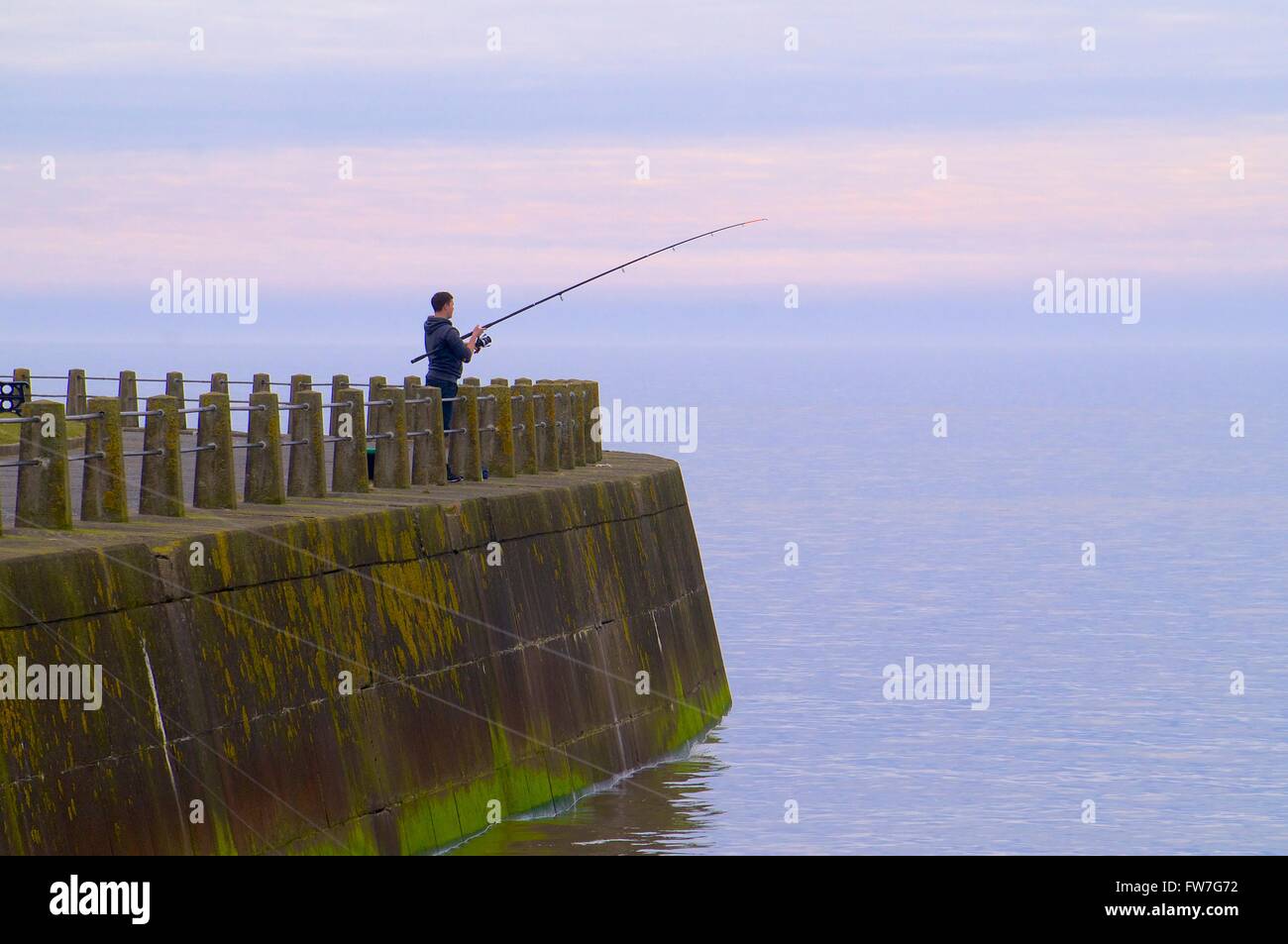 Sea fisherman fishing of the sea wall. Evening. Silloth, Cumbria ...