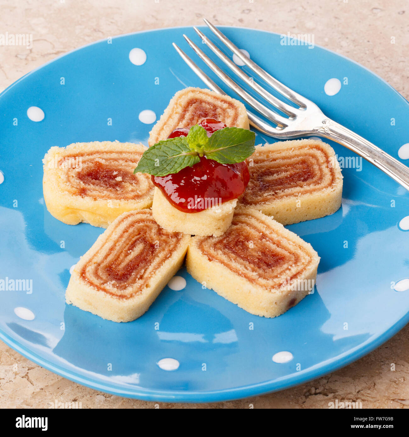 Bolo de rolo (swiss roll, roll cake) Brazilian dessert on blue plate on ...