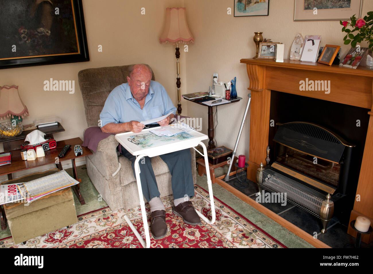 Elderly man sitting inside opening his mail Stock Photo - Alamy