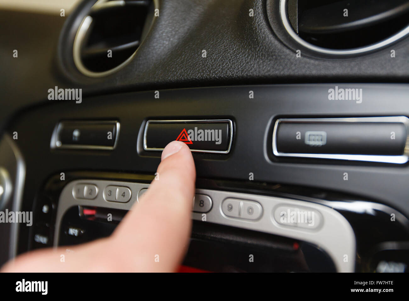 Man pressing emergency button on car dashboard (Shallow DOF Stock Photo ...