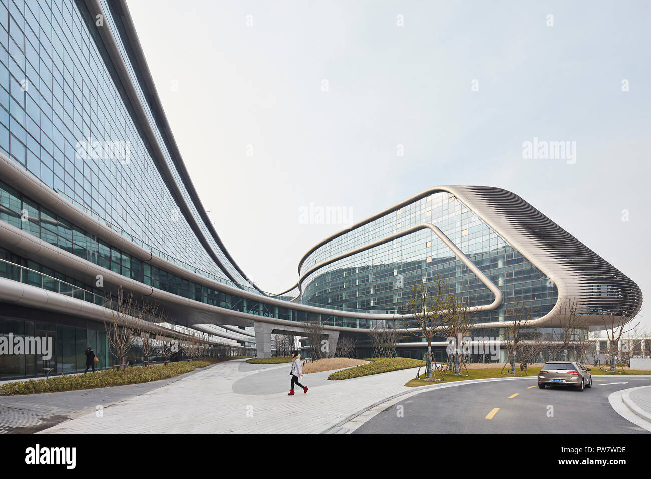 Walkway and curved glass curtain wall with pedestrian and street. Sky ...