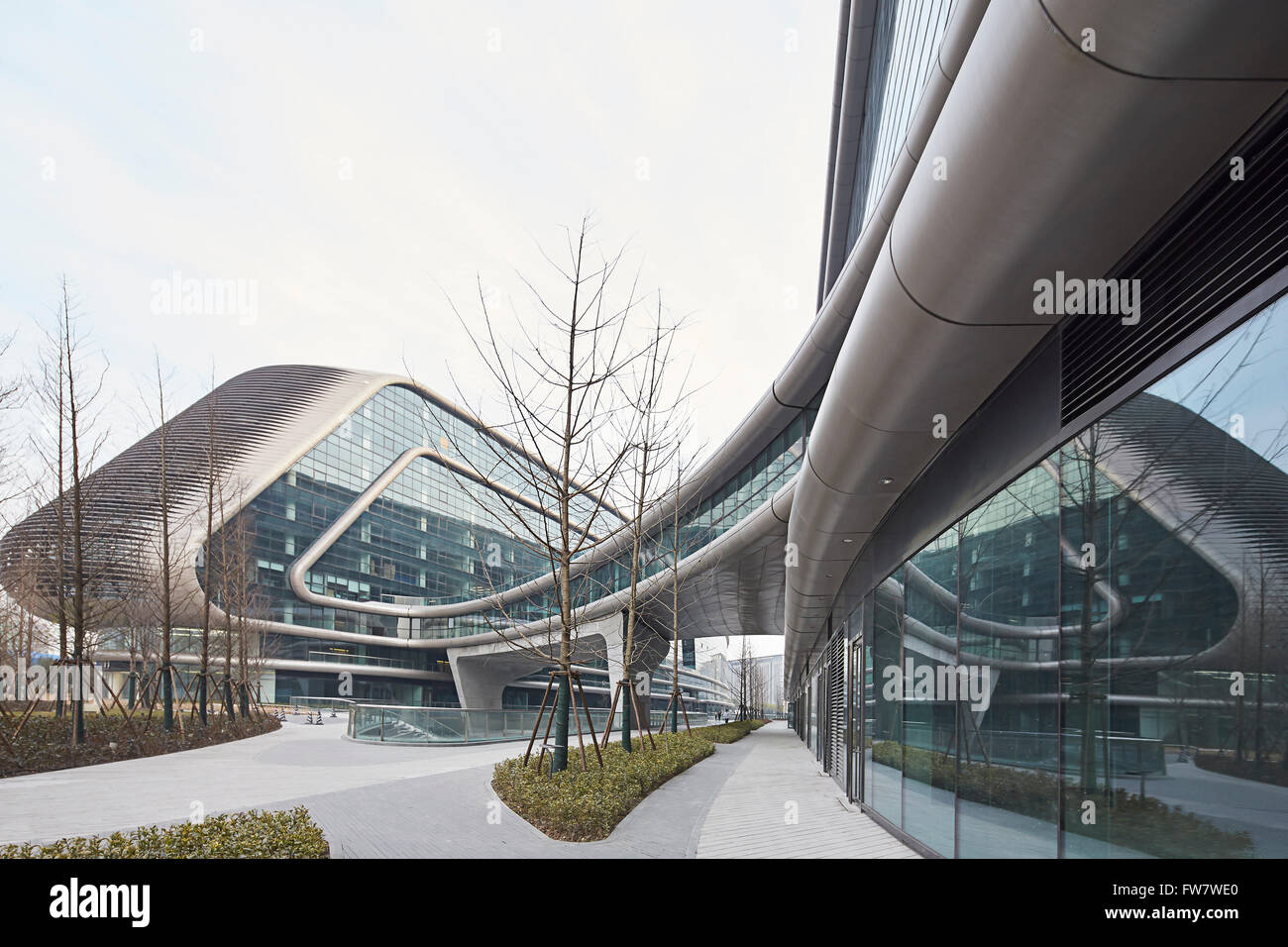 Glass curtain wall of exterior facade and landscaped walkways. Sky SOHO ...