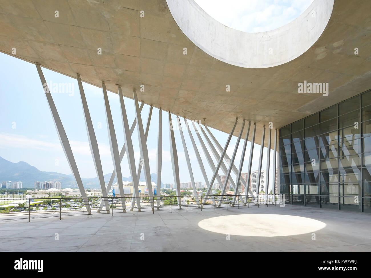 Canopied public plaza and terrace with circular void and city view. La ...
