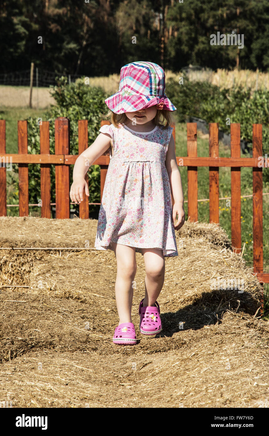 Little girl is walking on the haystack. Leisure activity Stock Photo ...