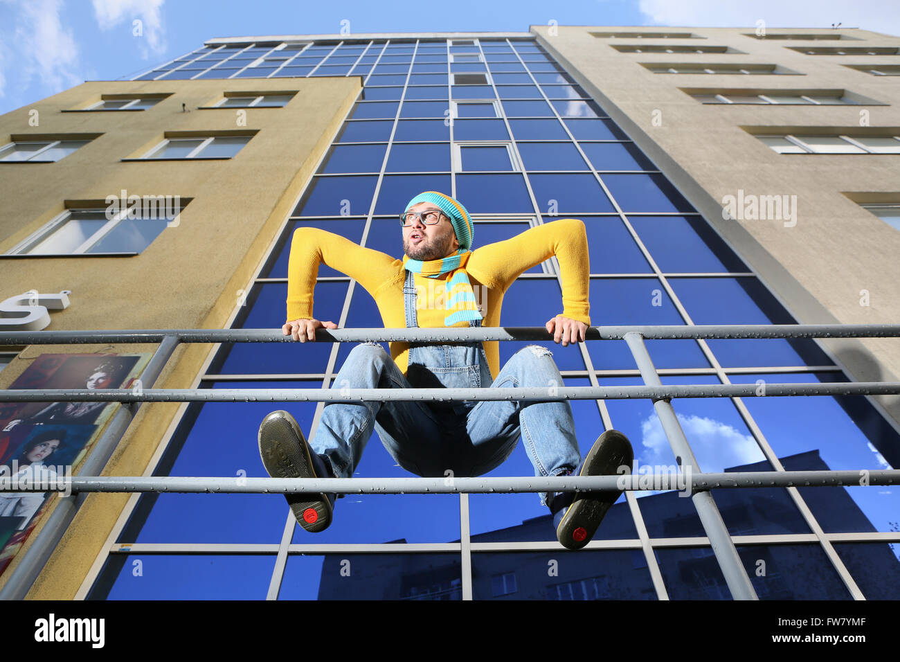 a young man in overalls on background glassed building Stock Photo - Alamy