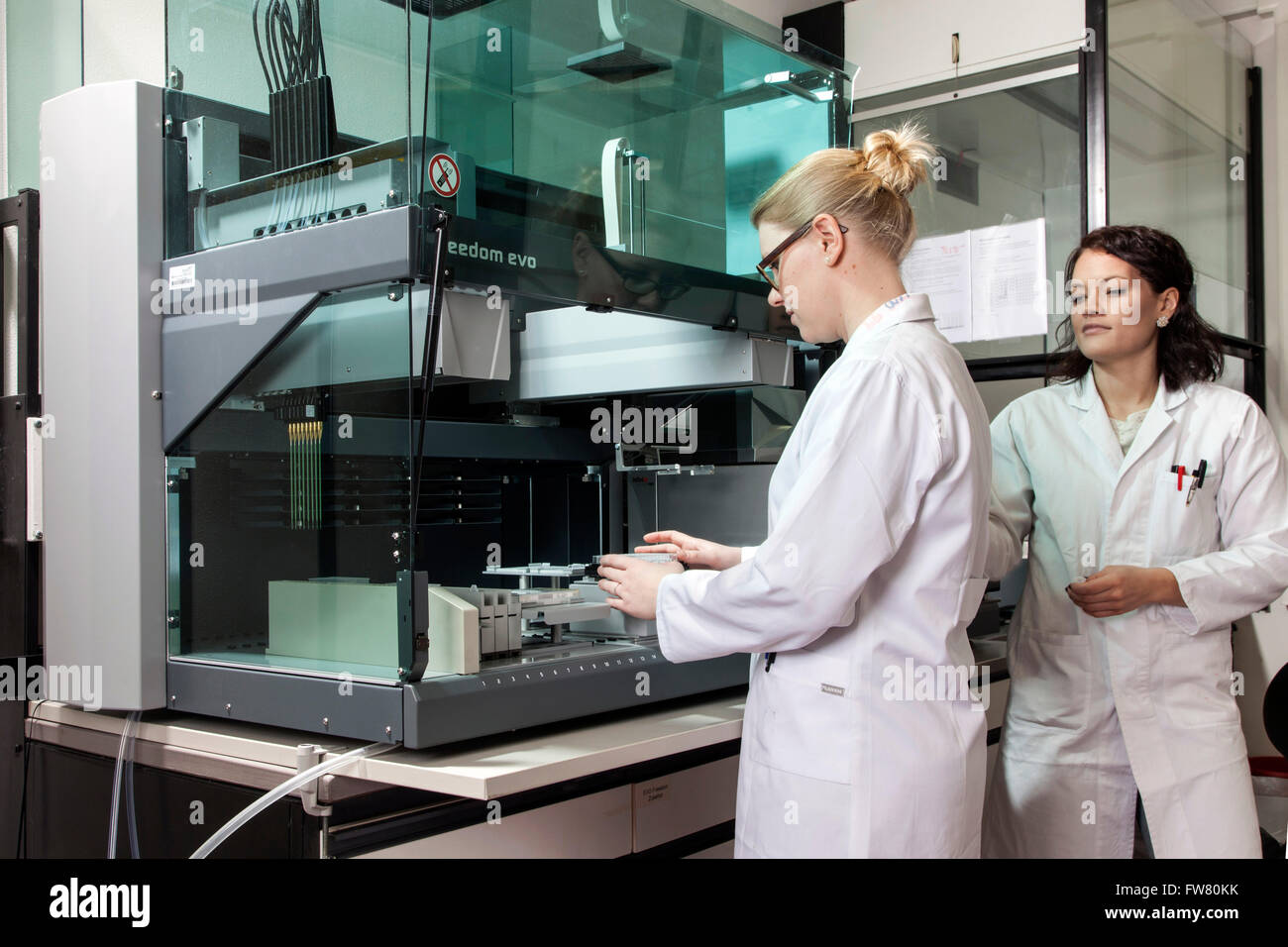 Scientist at a pipetting robot Stock Photo - Alamy