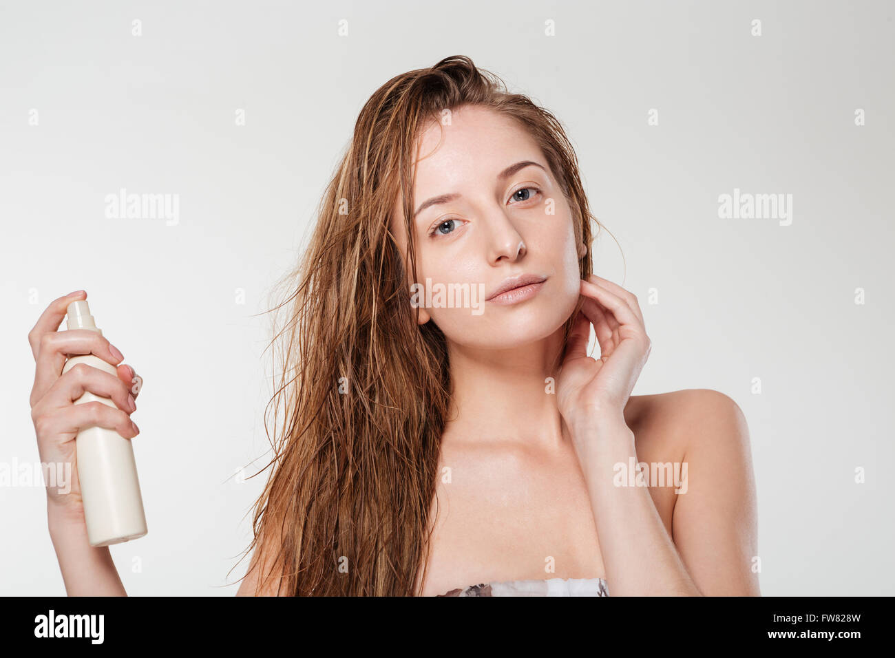 Young woman spraying hairspray isolated on a white background Stock ...