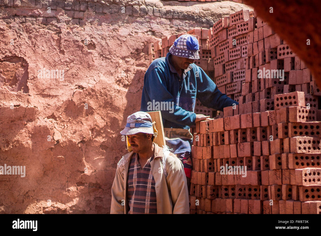 April 1, 2016 - A man loads bricks on the back of another man from the ...