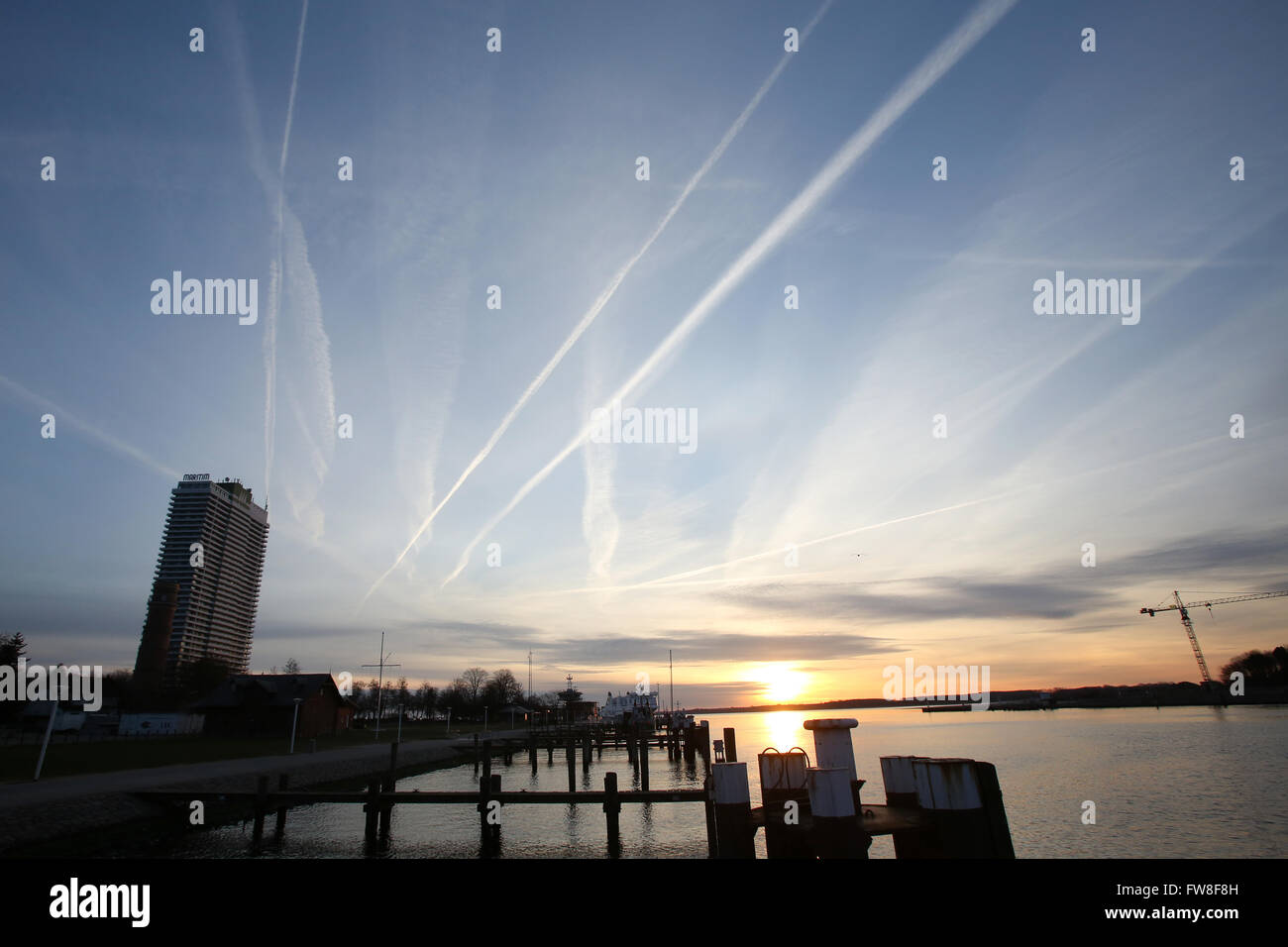 Contrails can be seen in the sky over the harbor in Luebeck-Travemuende ...