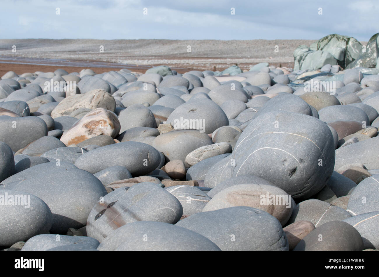 Pebbles at the beach in the foreground of a coastal scene Stock Photo ...