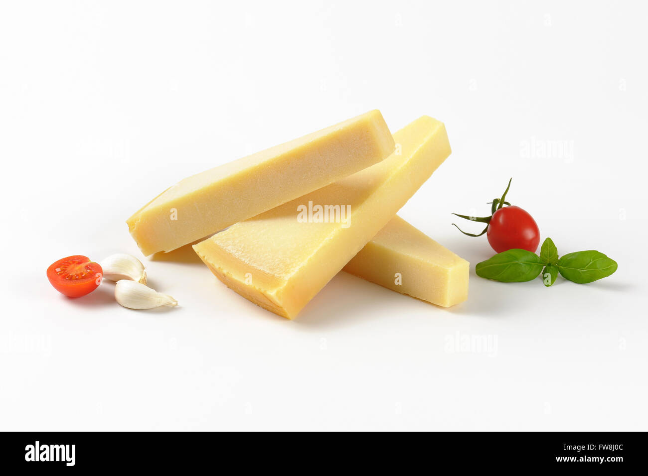 three wedges of fresh parmesan cheese and garnish on white background ...