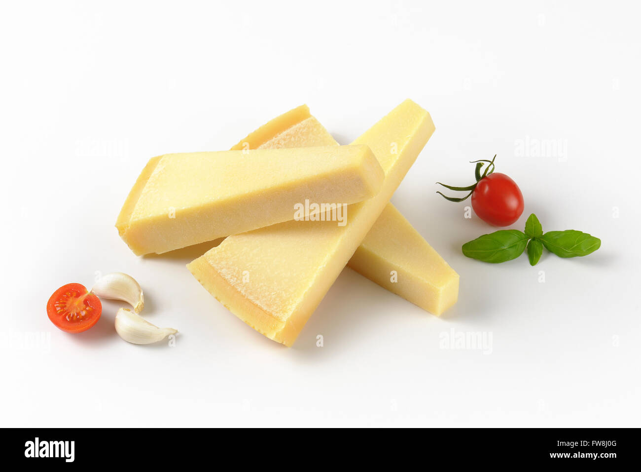 three wedges of fresh parmesan cheese and garnish on white background ...