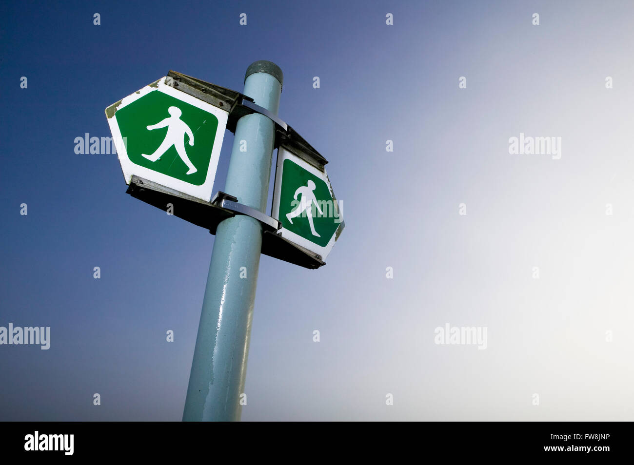 A footpath sign on a pole indicating the way that the walker should go ...