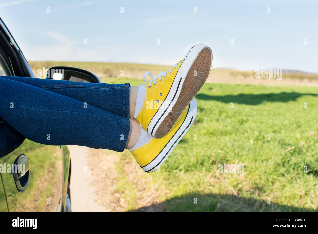 Woman legs out of the car window. Travel and fun Stock Photo - Alamy