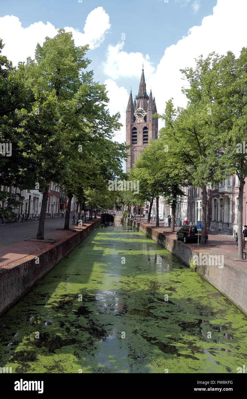 The tower of Oude Kerk (Old Church) viewed along a canal in Delft ...