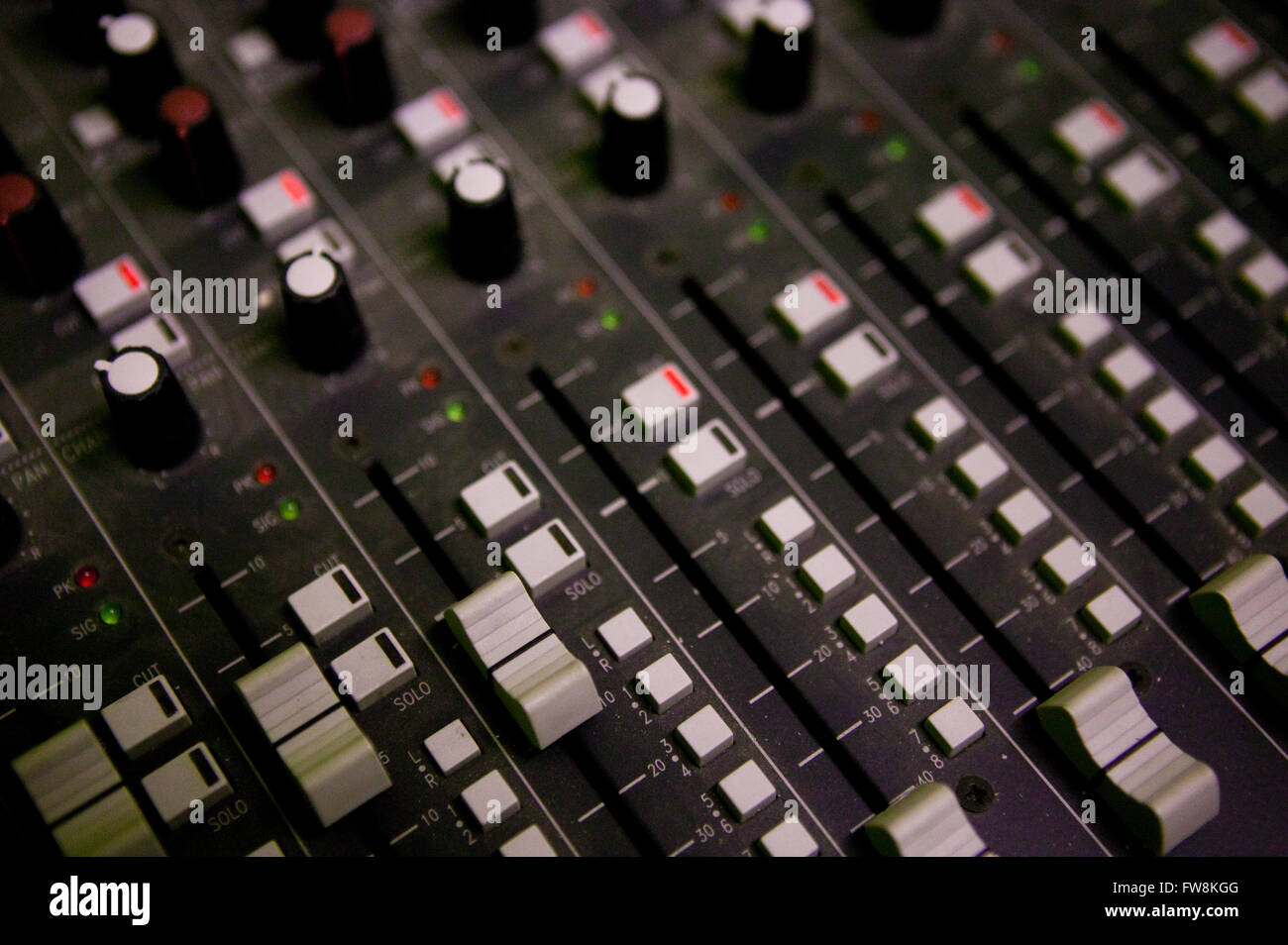 Detail of a mixing desk in a small recording studio showing the dials ...