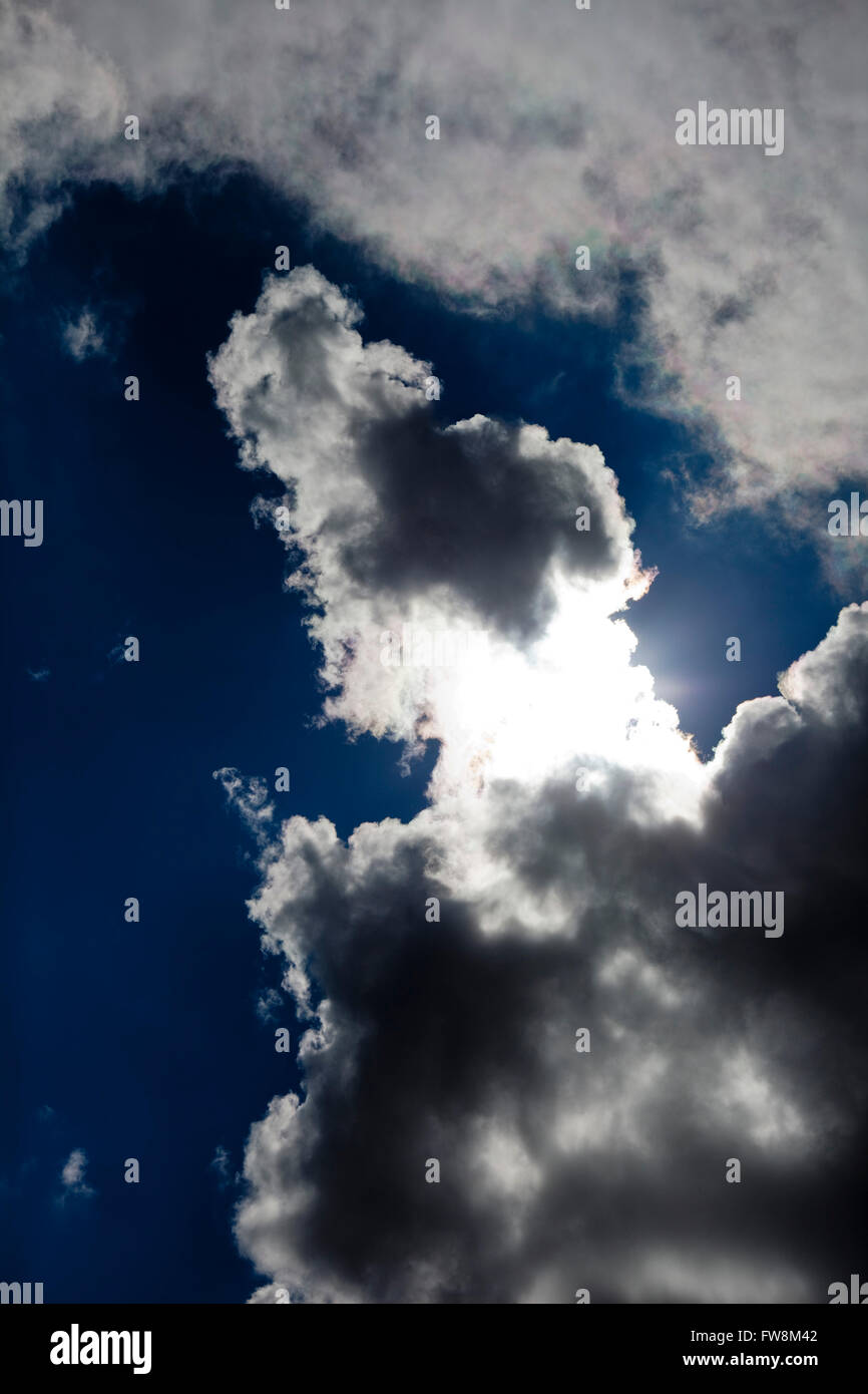 Sun rays exploding from behind a cloud in a blue sky Stock Photo - Alamy